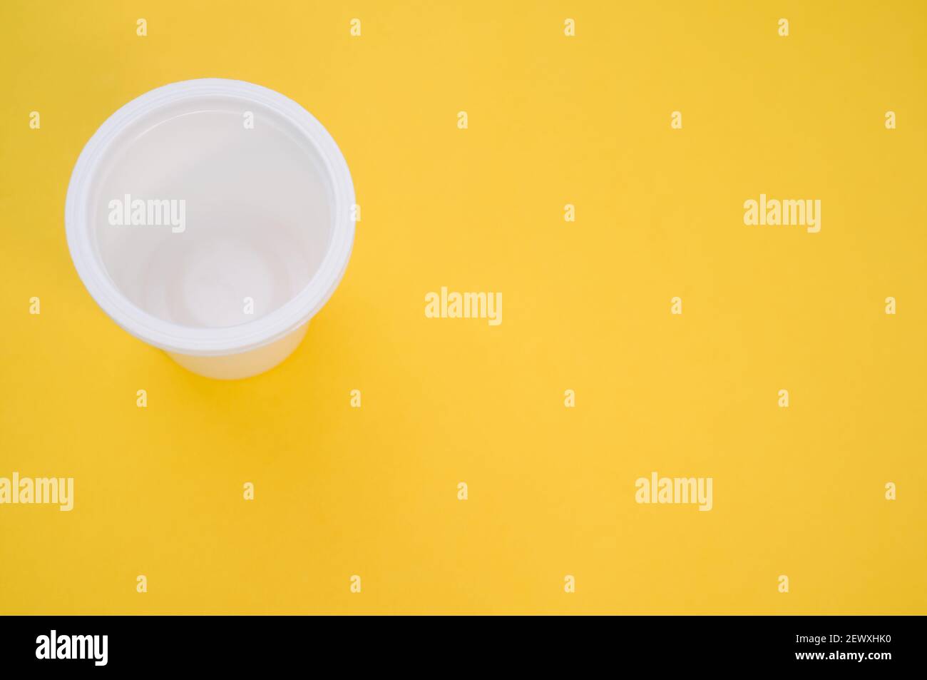 A top view of a disposable plastic cup isolated on a yellow background ...