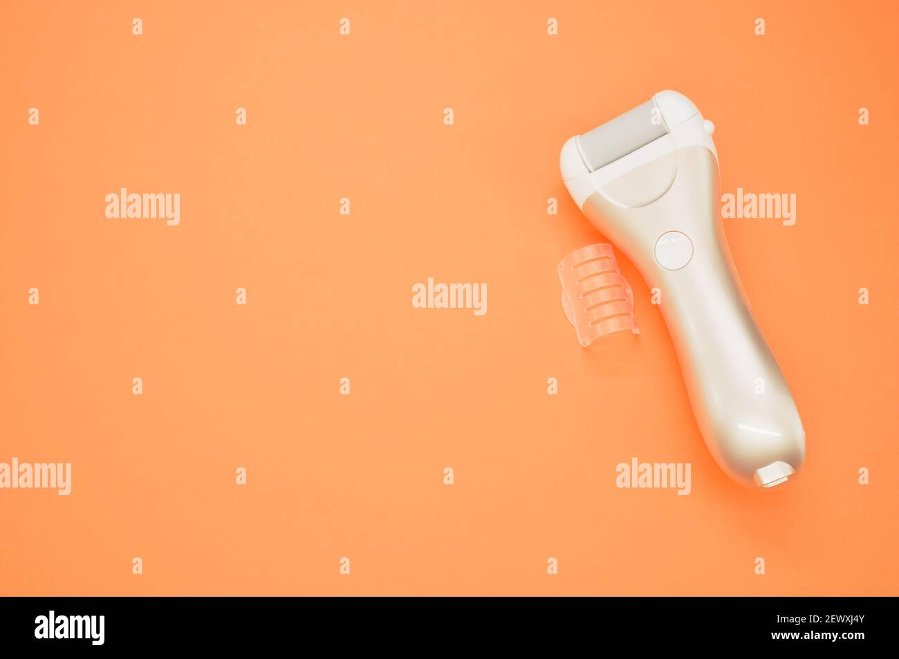 A top view of an electric foot file isolated on an orange background ...
