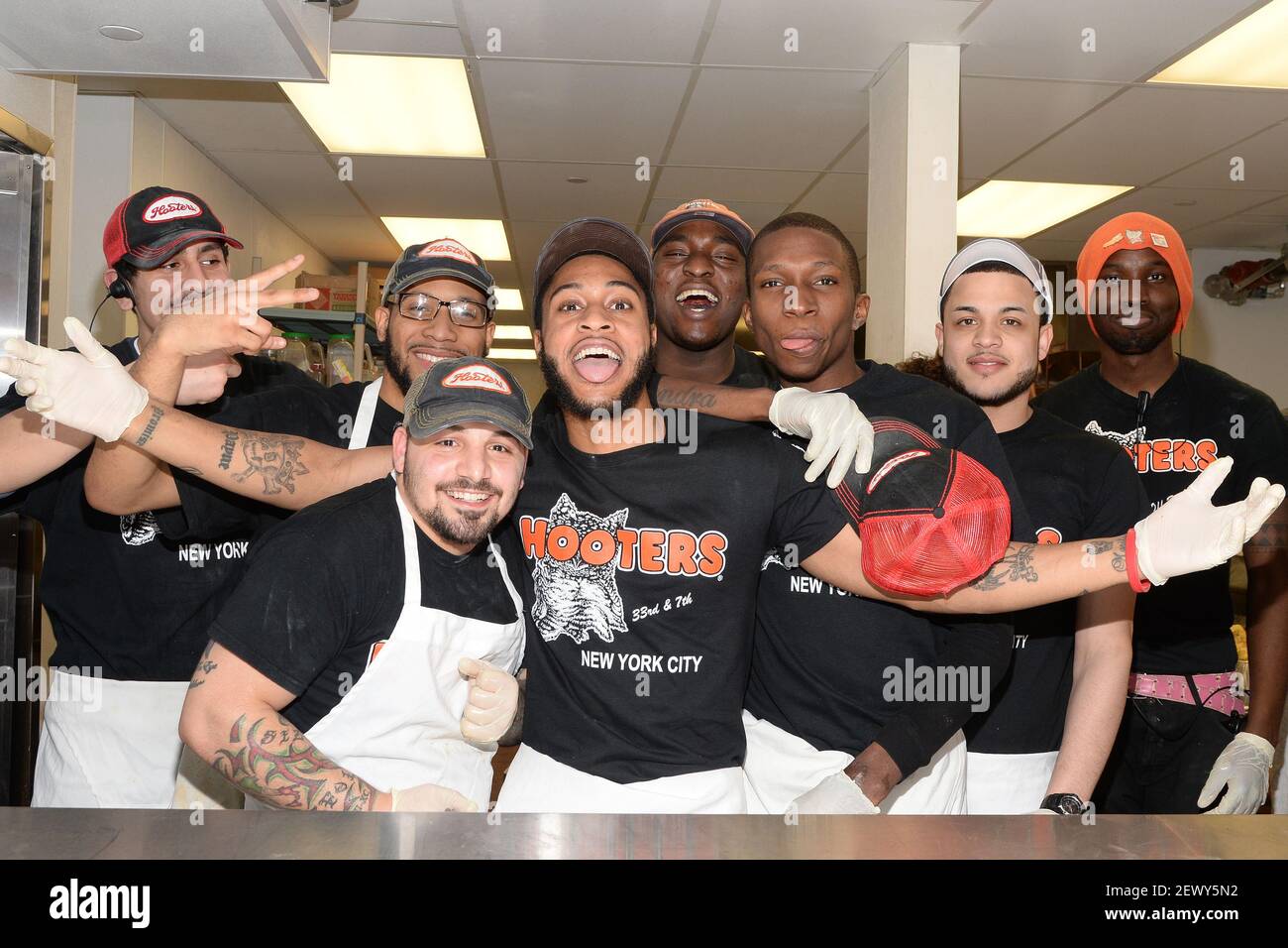 Cooks pose for a photo at the Hooters Manhattan VIPress Preview Party ...