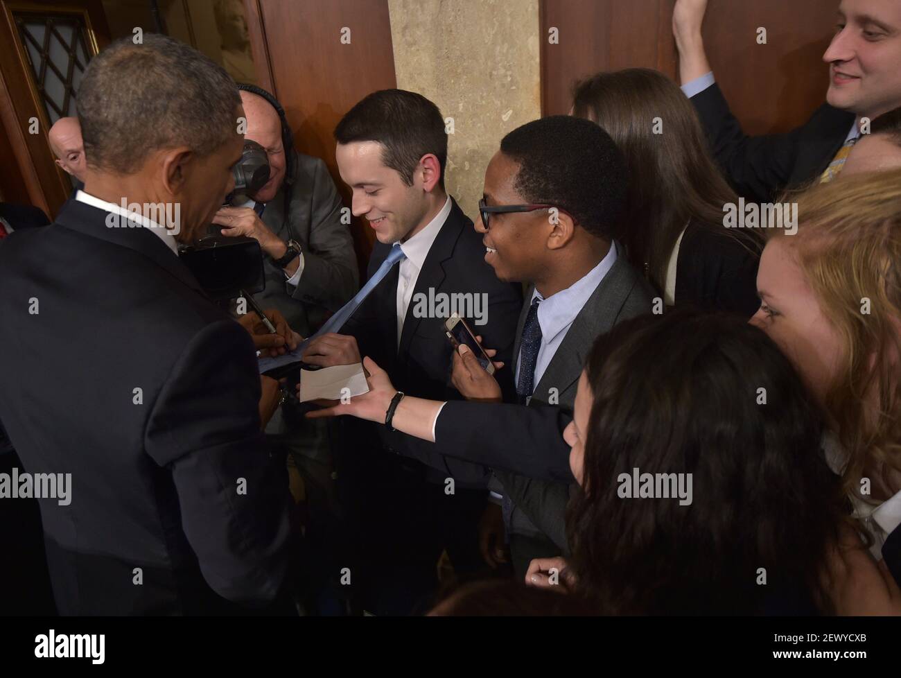US President Barack Obama (L) autographs the tie of an unidentified ...