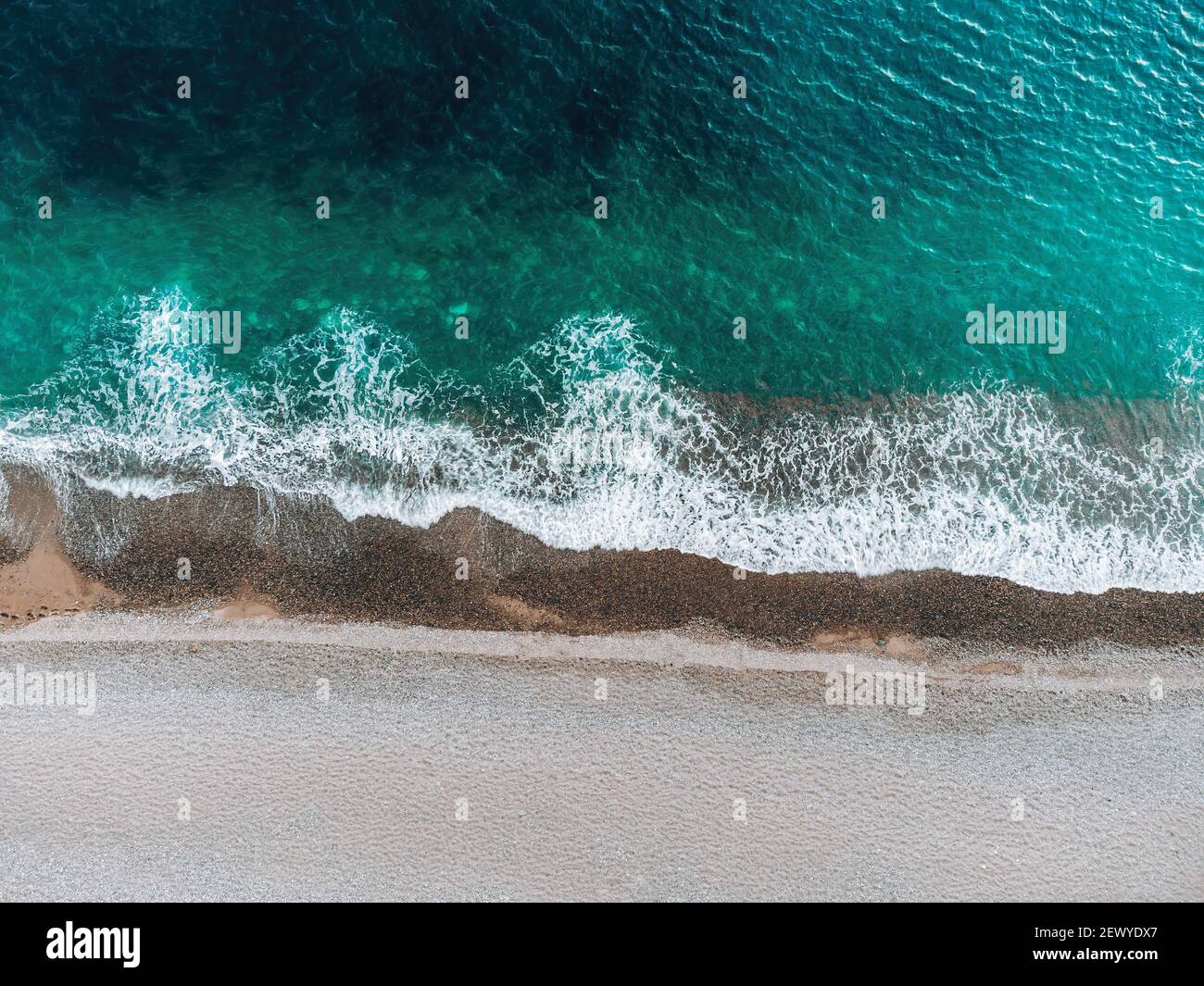 Aerial view from above on azure sea and pebbles beach. Small waves on ...