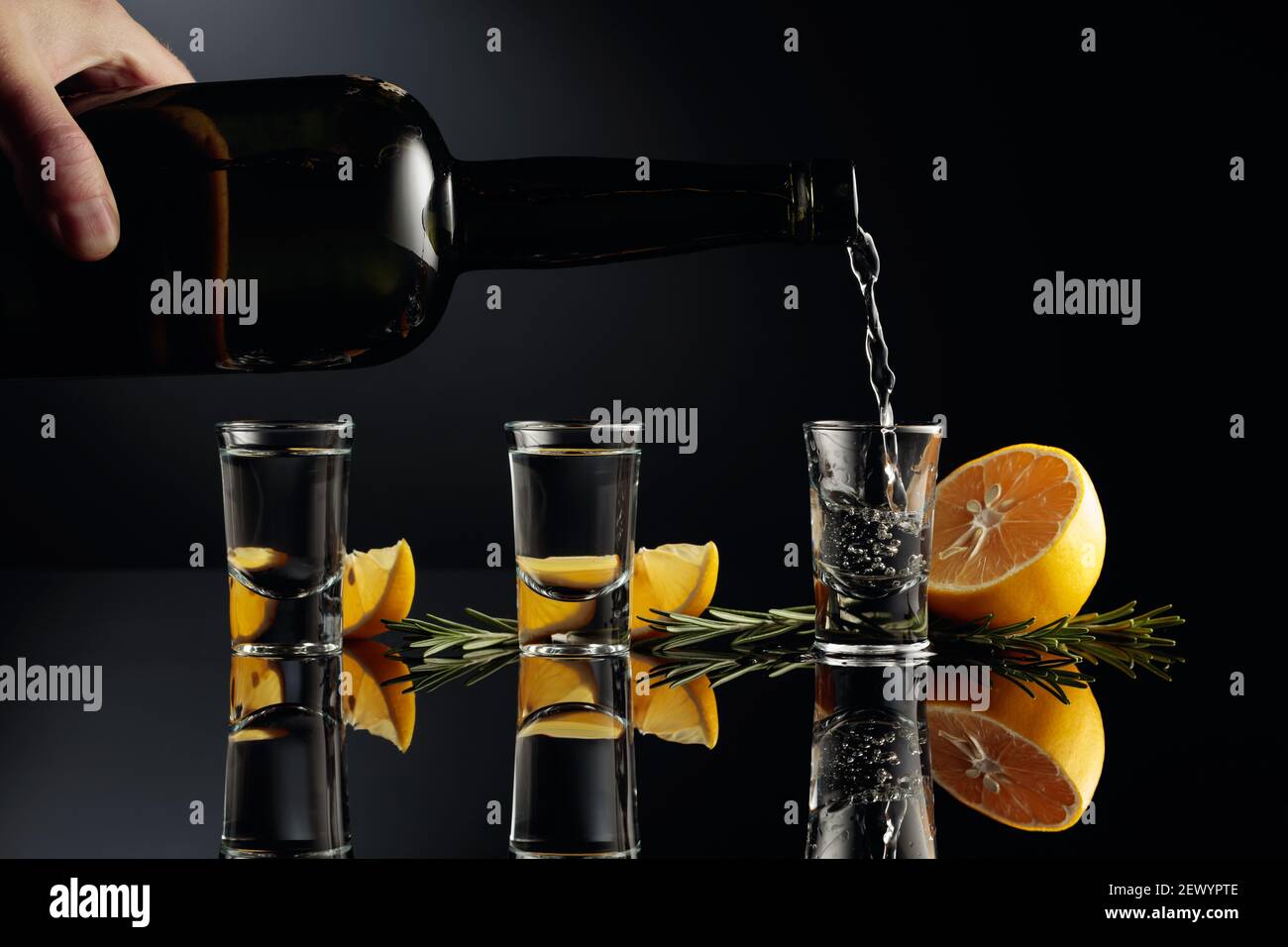 Gin is poured in a small glass from an antique bottle of dark glass. A ...
