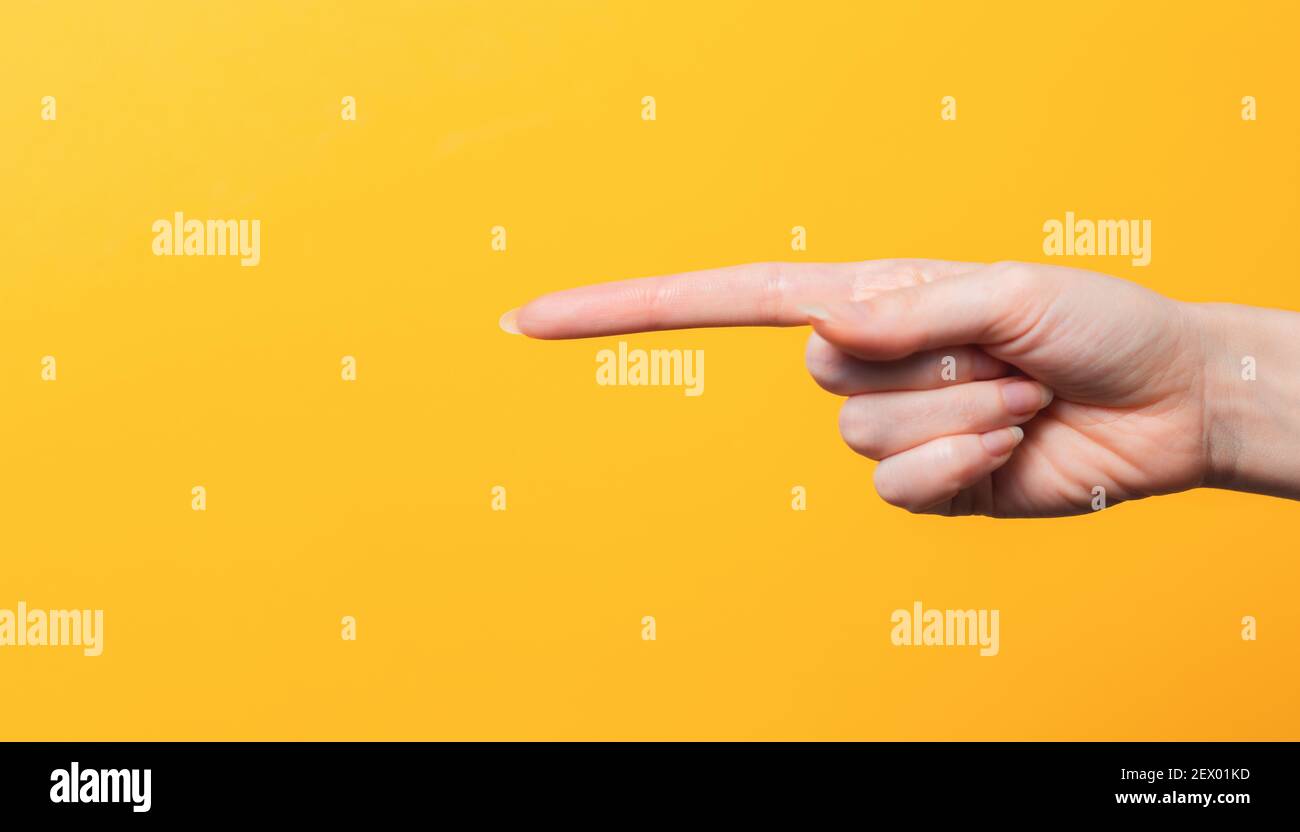 Female hand close-up, long index finger pointing at something. Gesture ...