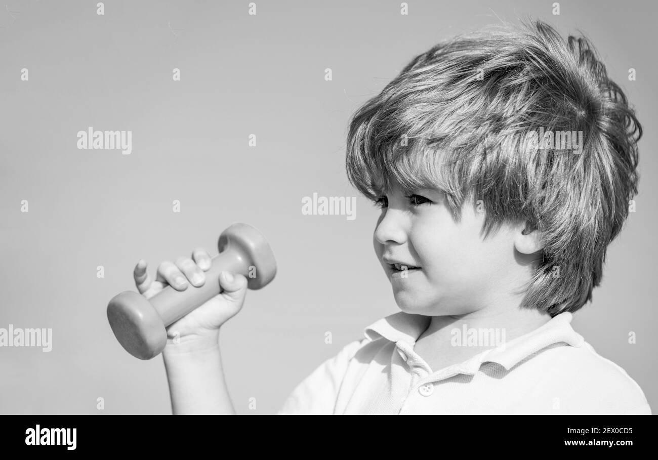 Fitness, health and energy. Cheerful boy do exercises with dumbbells ...