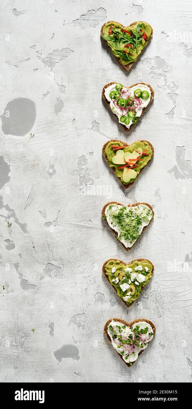 Top view of line of yummy heart shaped bruschettas with vegetables and ...