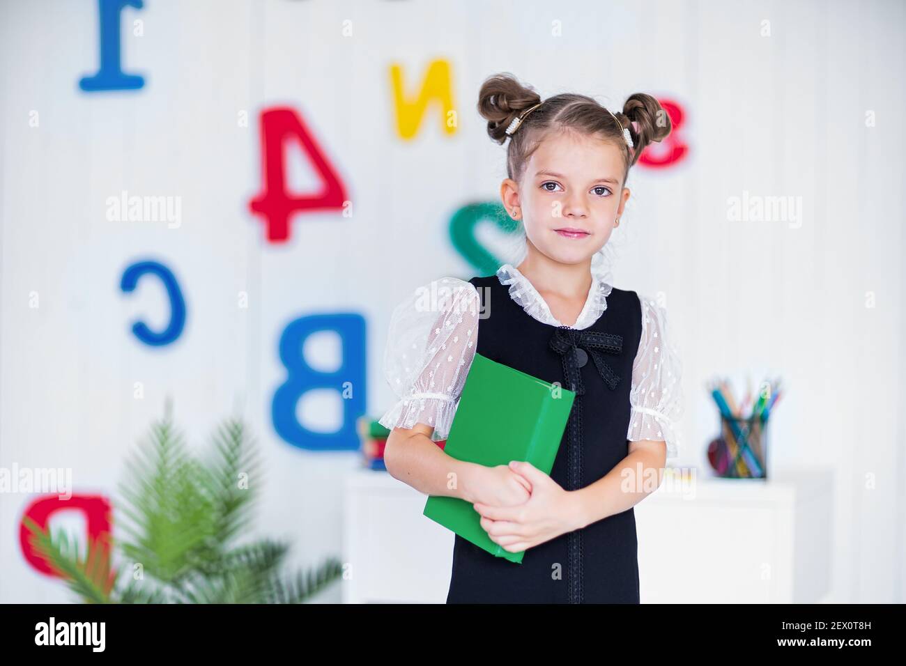 Happy smart girl in school unifrom hold book and look at camera Stock ...