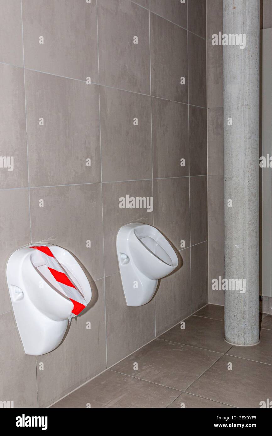 a barrier tape sticks to a urinal in the men's toilet Stock Photo - Alamy