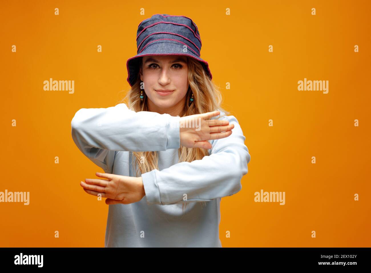 Stylish girl in panama hat dancing against yellow background Stock ...