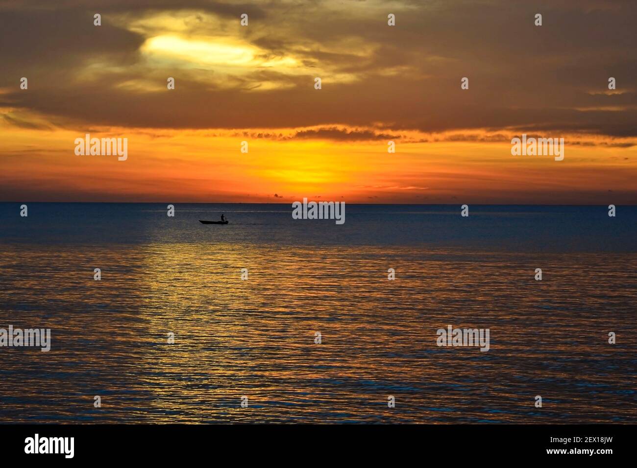 Evening Sunset At The Beach And Fisherman Fishing From Afar Stock Photo ...