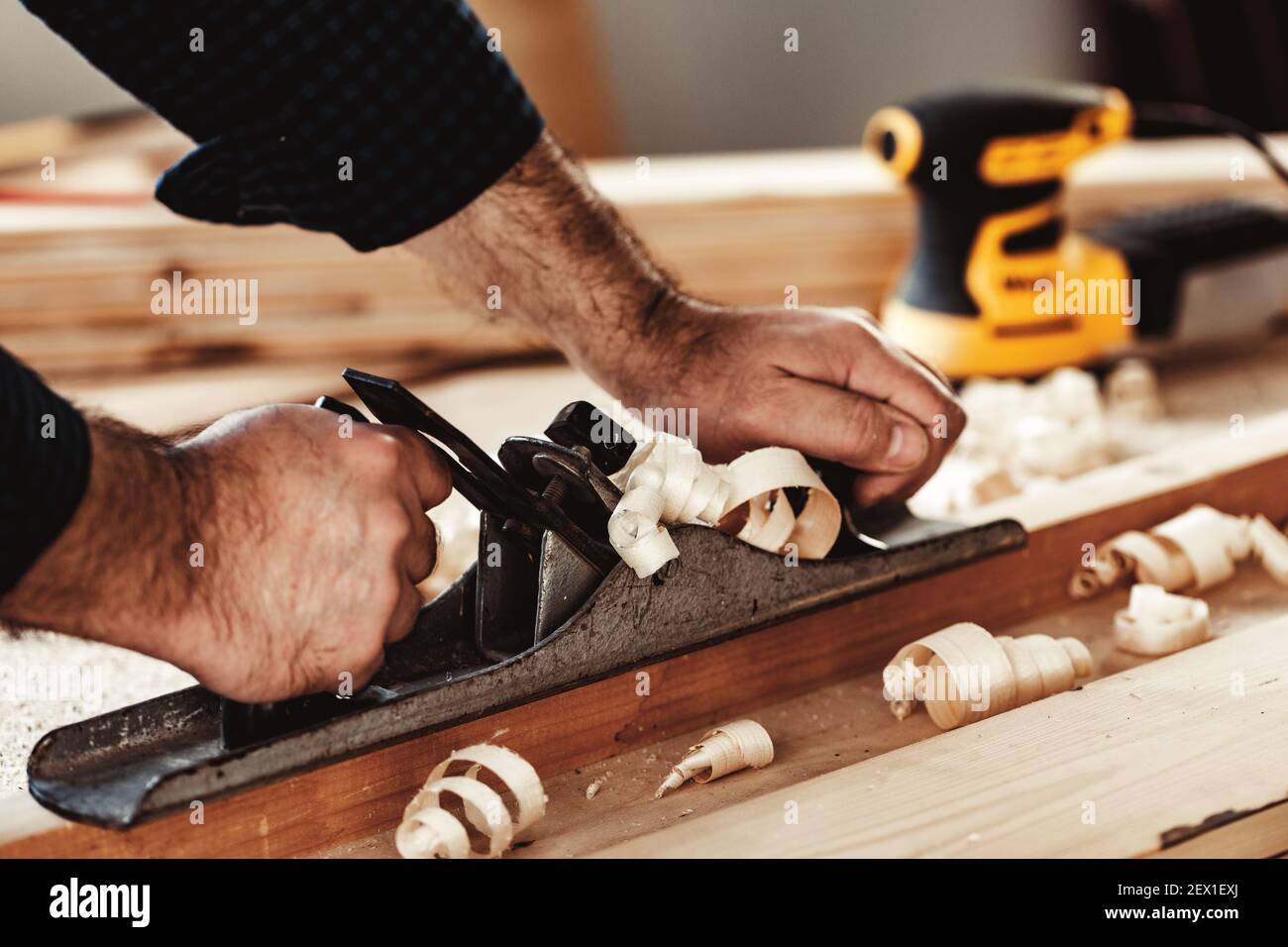 Carpenter's hands planing a plank of wood with a hand plane Stock Photo ...