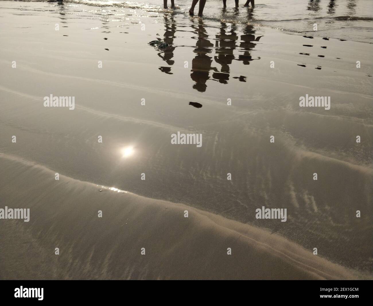 A beautiful shot of sand on the beach in Mumbai with people’s ...