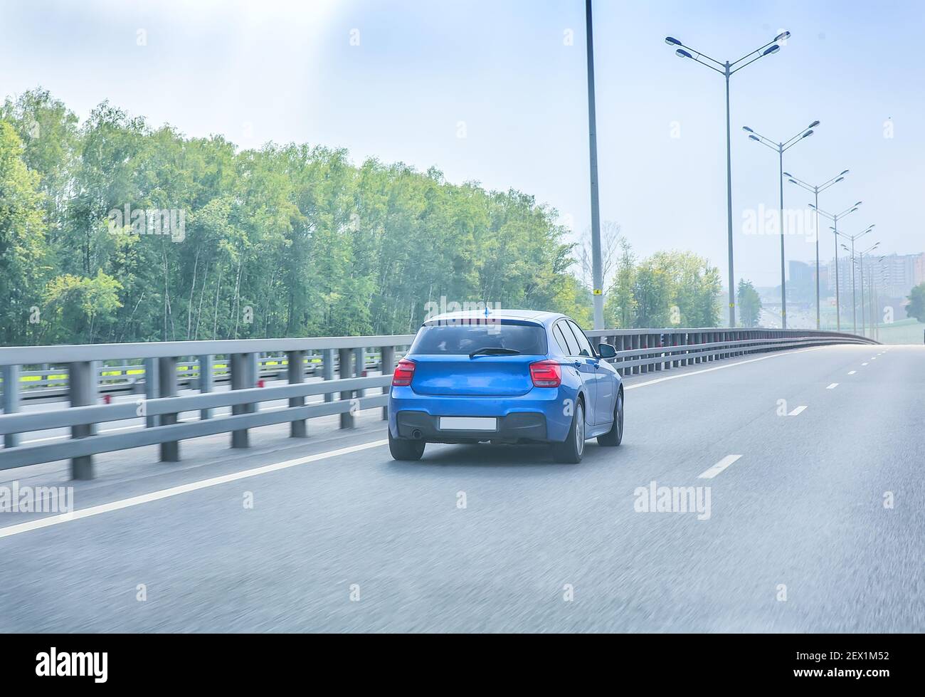 blue car goes on country highway Stock Photo - Alamy
