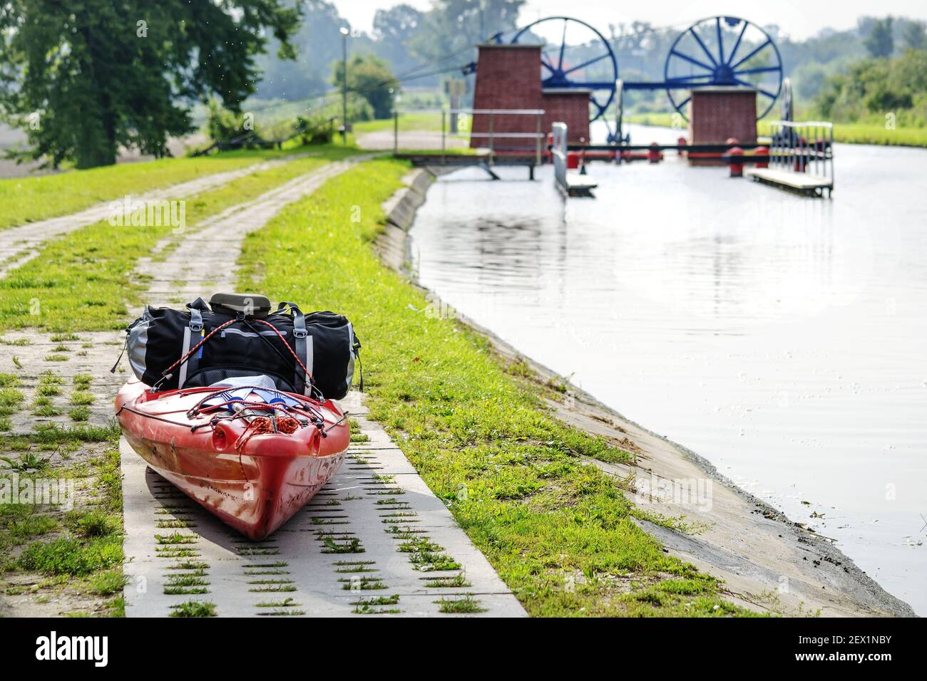 A red kayak with a traveling bag next to Elblag Canal in the background ...