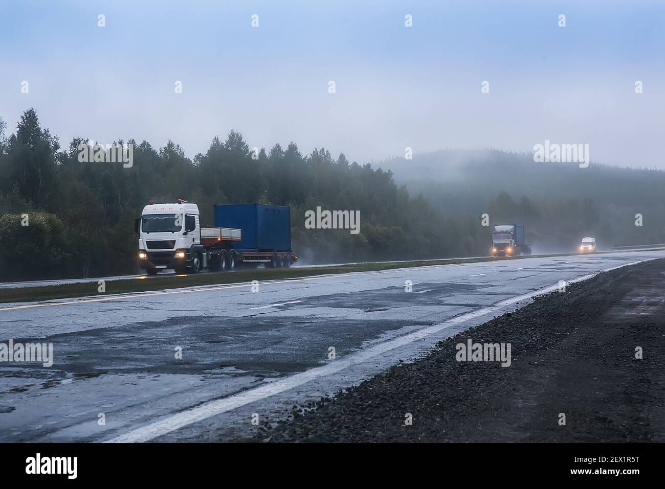 trucks with containers go in the fog along the country road Stock Photo ...