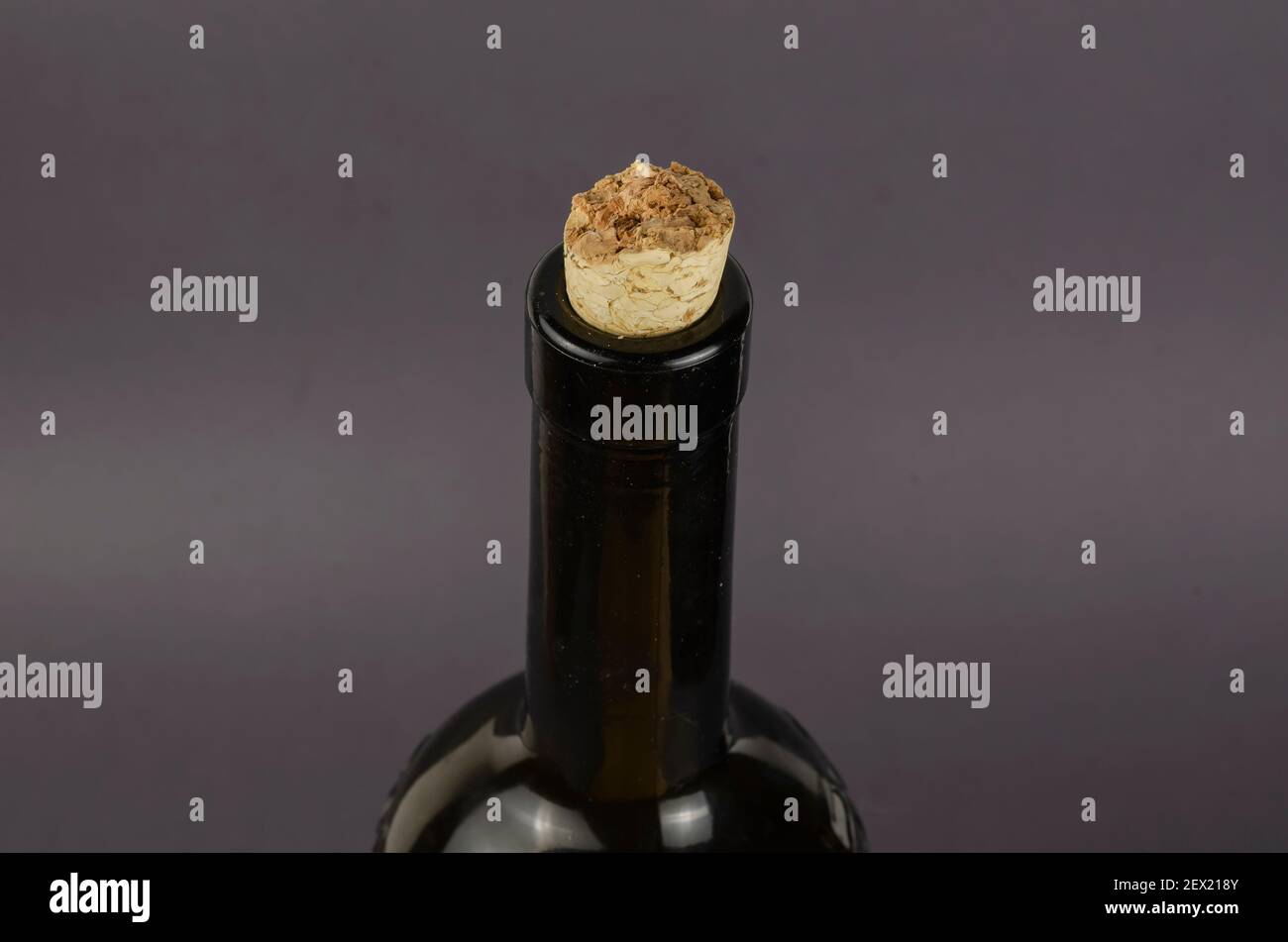 Wine bottle with broken cork on gray background. A bottle of red wine ...