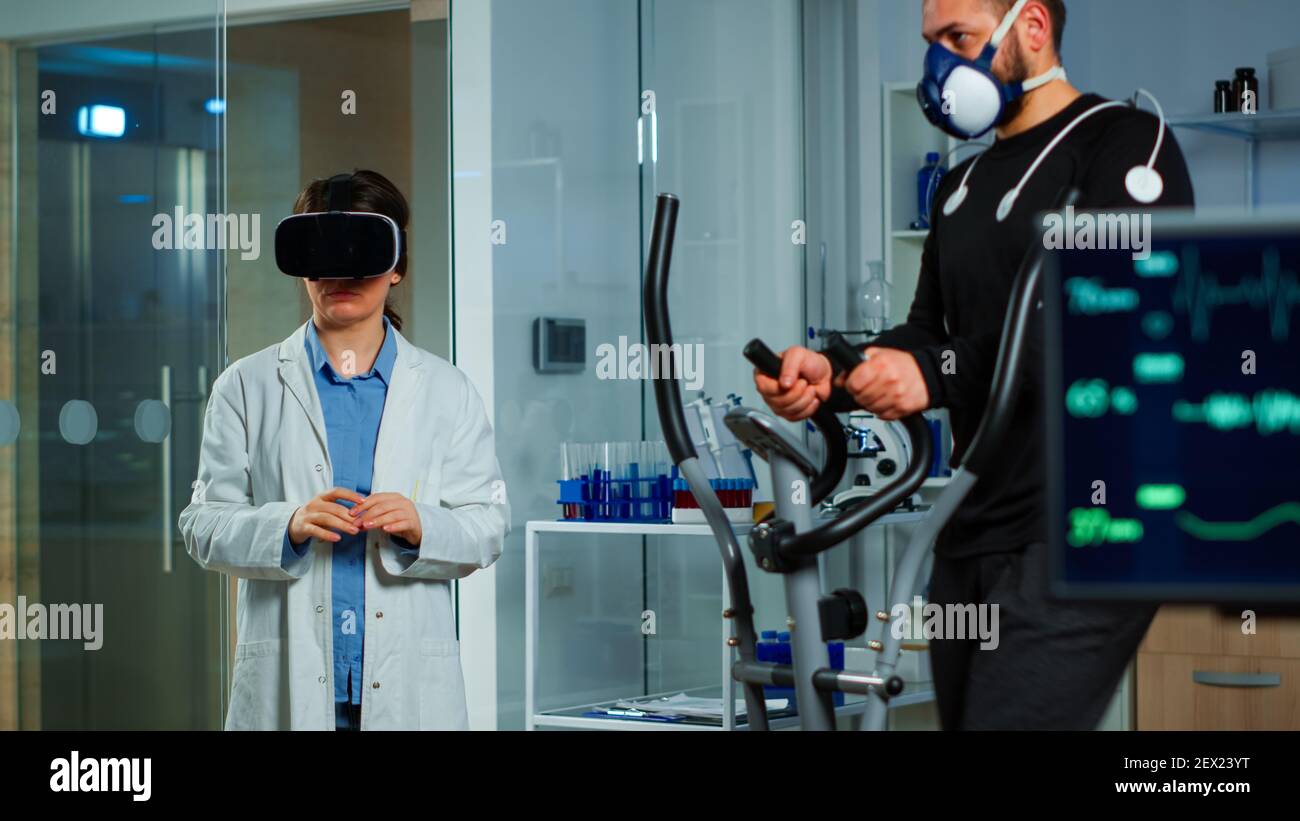 Scientist doctor in sport science laboratory wearing virtual reality ...