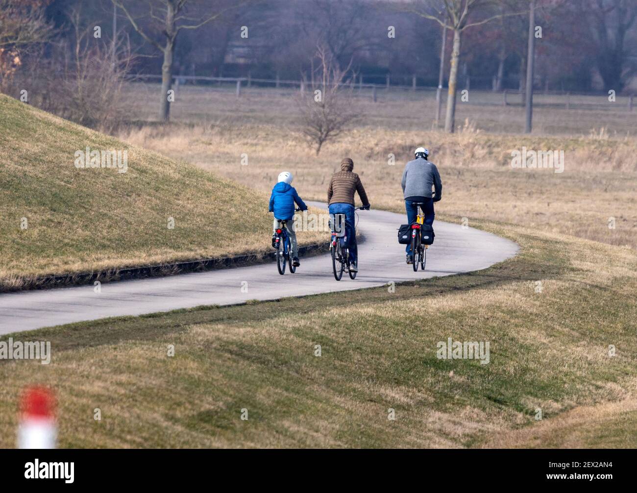 Bleckede, Germany. 02nd Mar, 2021. Cyclists are on the path behind the ...