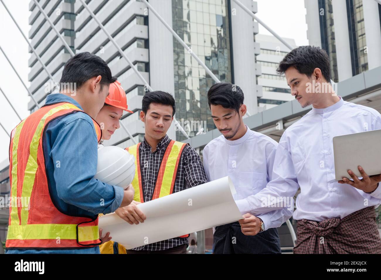 Team of engineer with myanmar businessman holding blueprint meeting and ...