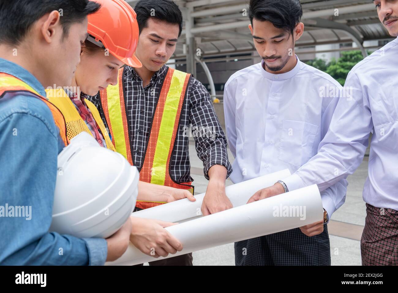 Team of engineer with myanmar businessman holding blueprint meeting and ...