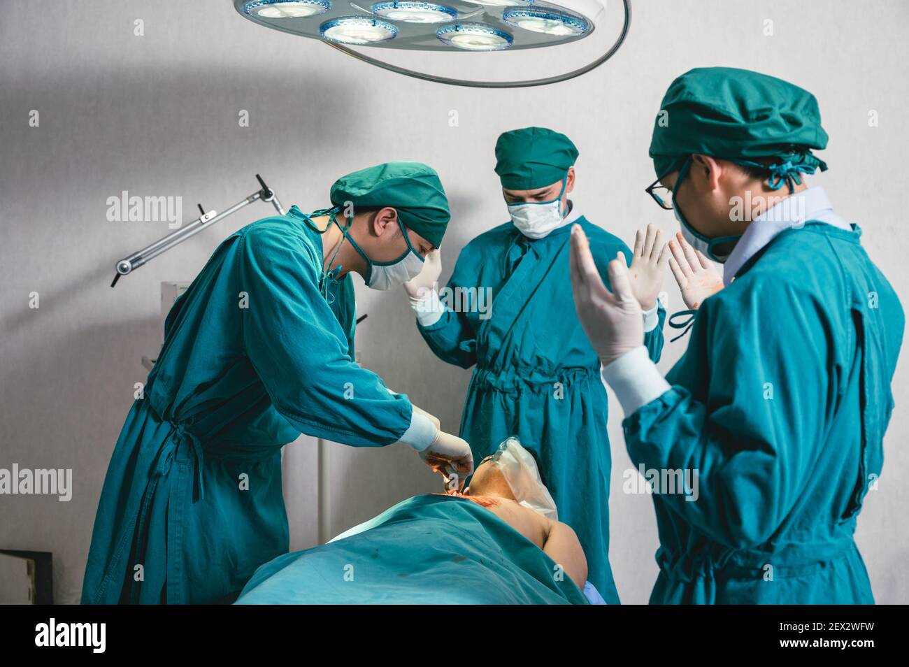 Asian surgeons team in surgical gown performing surgery a seriously ...