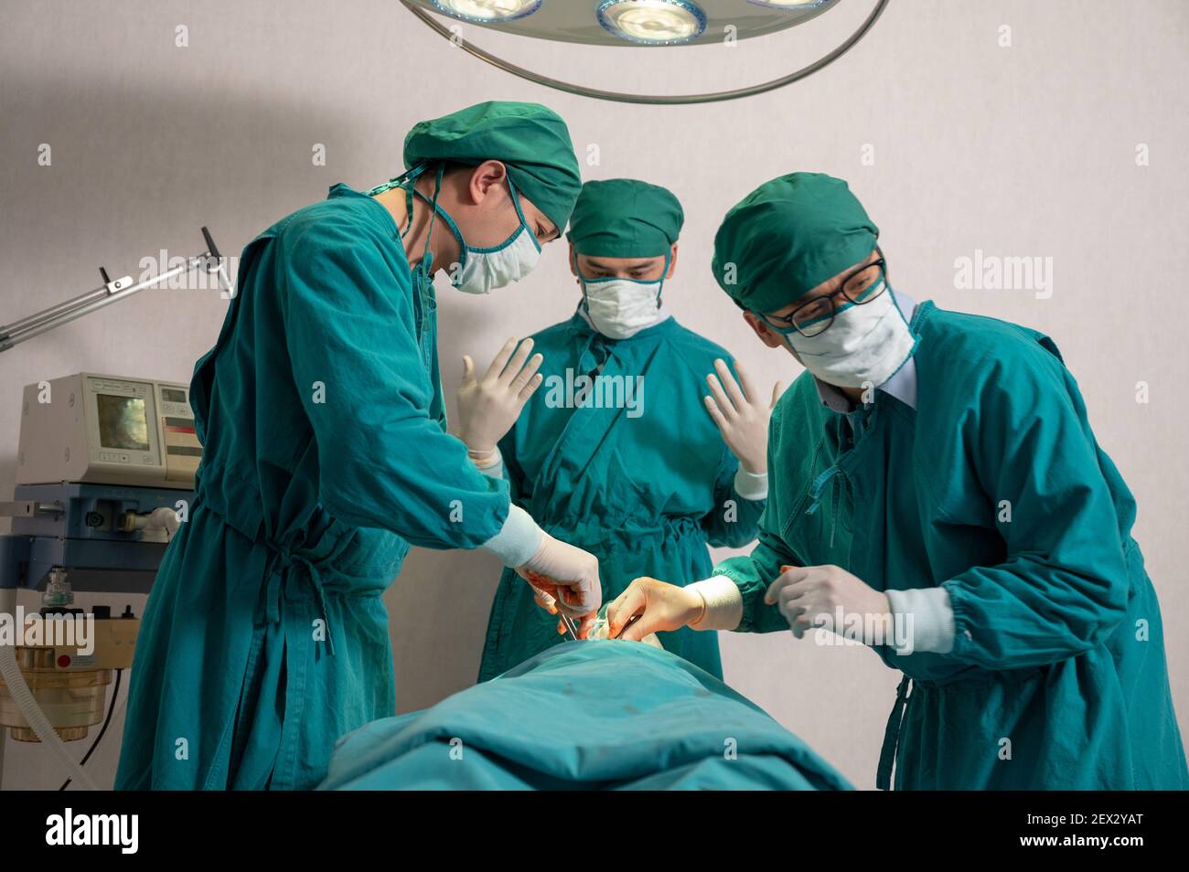 Asian surgeons team in surgical gown performing surgery a seriously ...