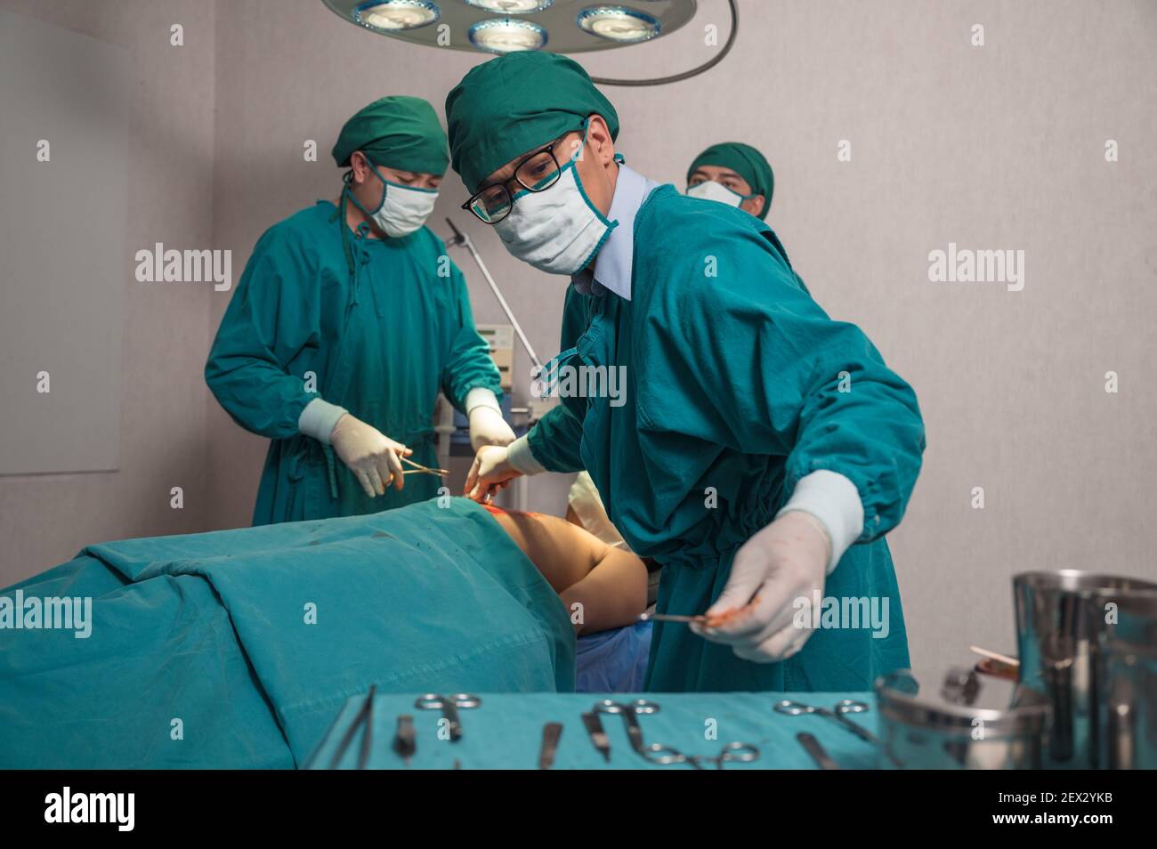 Asian surgeons team performing surgery a seriously injured patient and ...