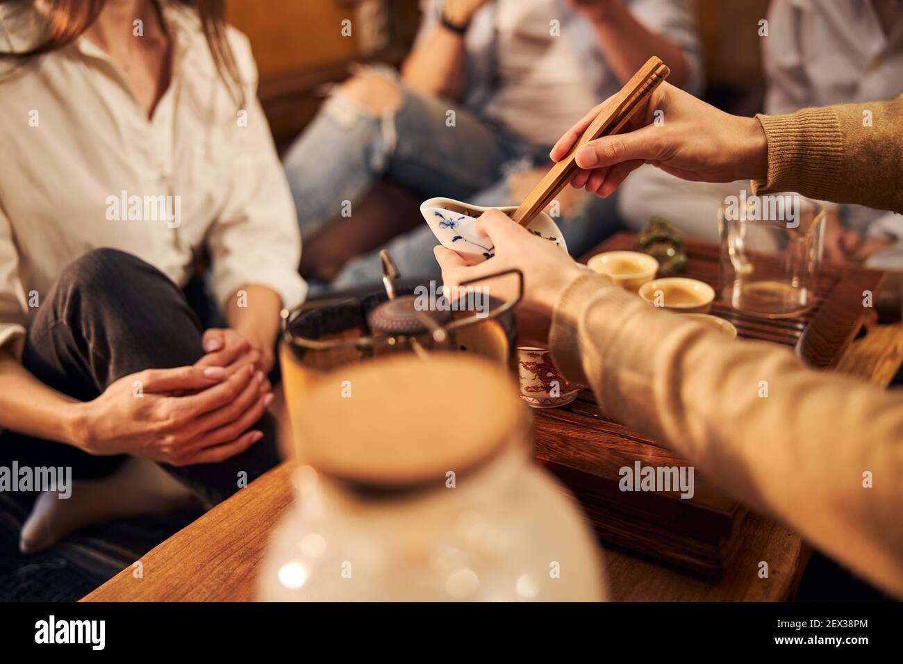 Young people having tea ceremony in cafe Stock Photo - Alamy