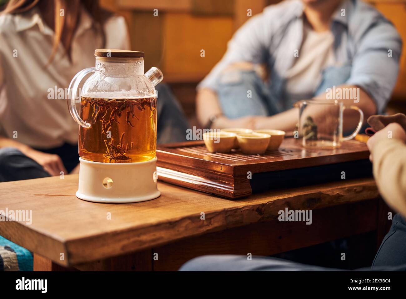 Delicious tea with young people on blurred background Stock Photo - Alamy