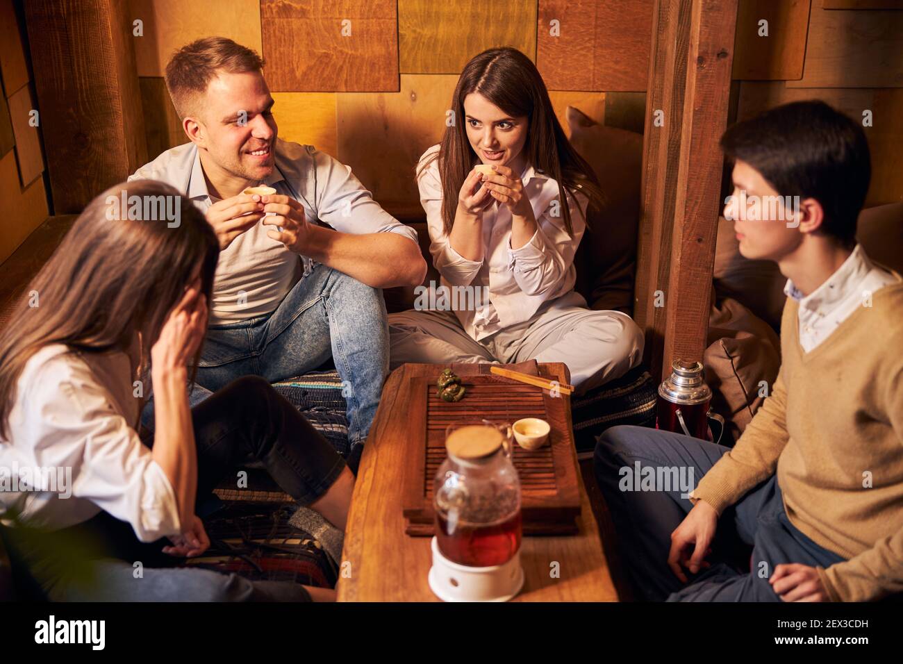 Group of friends enjoying tea ceremony in cafe Stock Photo - Alamy