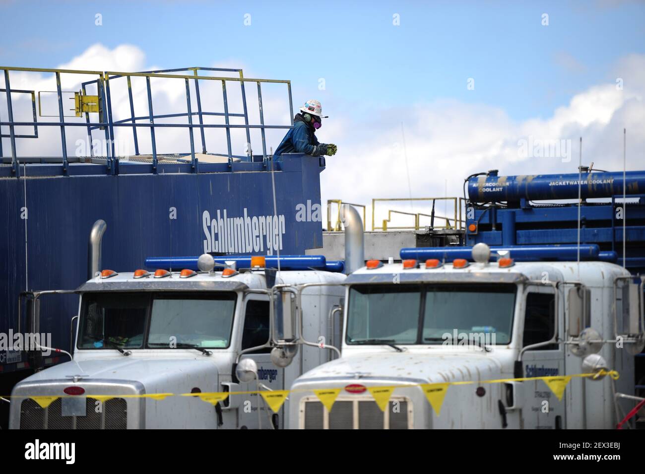 Schlumberger trucks with 2000 horsepower pumps direct water, sand and ...