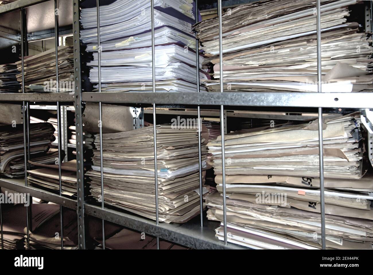 Open shelves with old files, folders and documents in an archive room ...