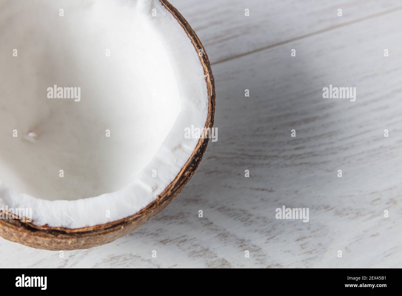 Coconut open in half seen from above with light wooden background Stock ...