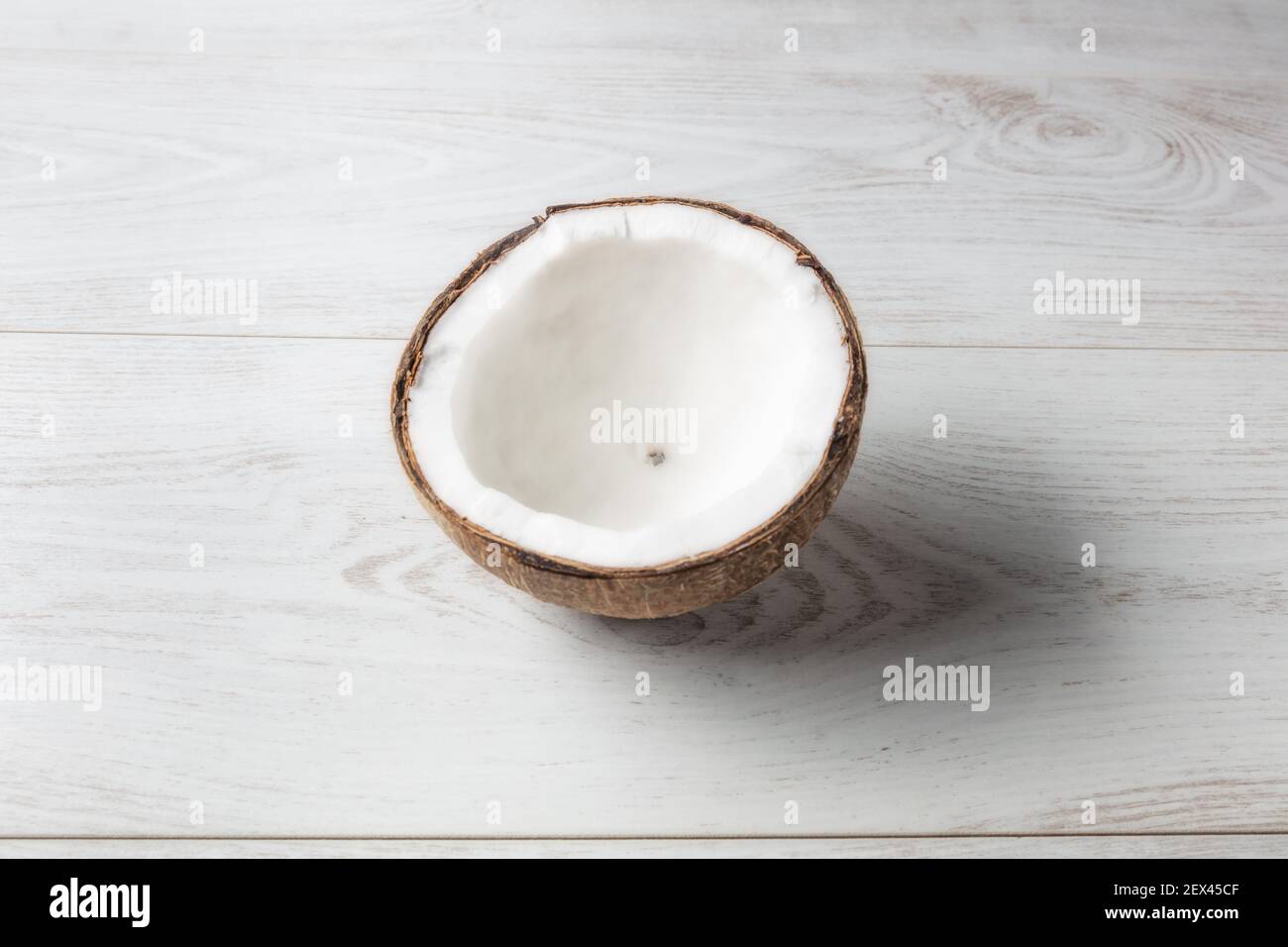 Coconut open in half seen from above with light wooden background Stock ...