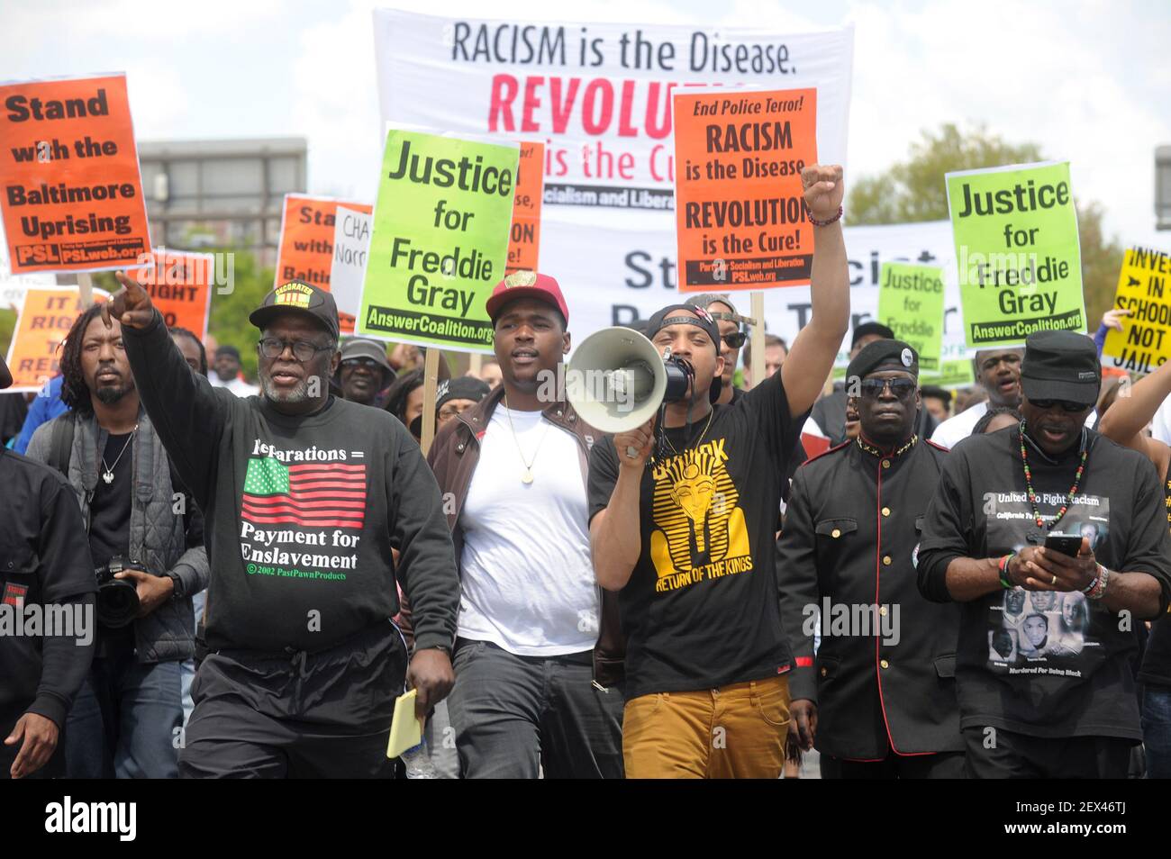 Kwame Rose, holding a megaphone, is surrounded by supporters as a group ...