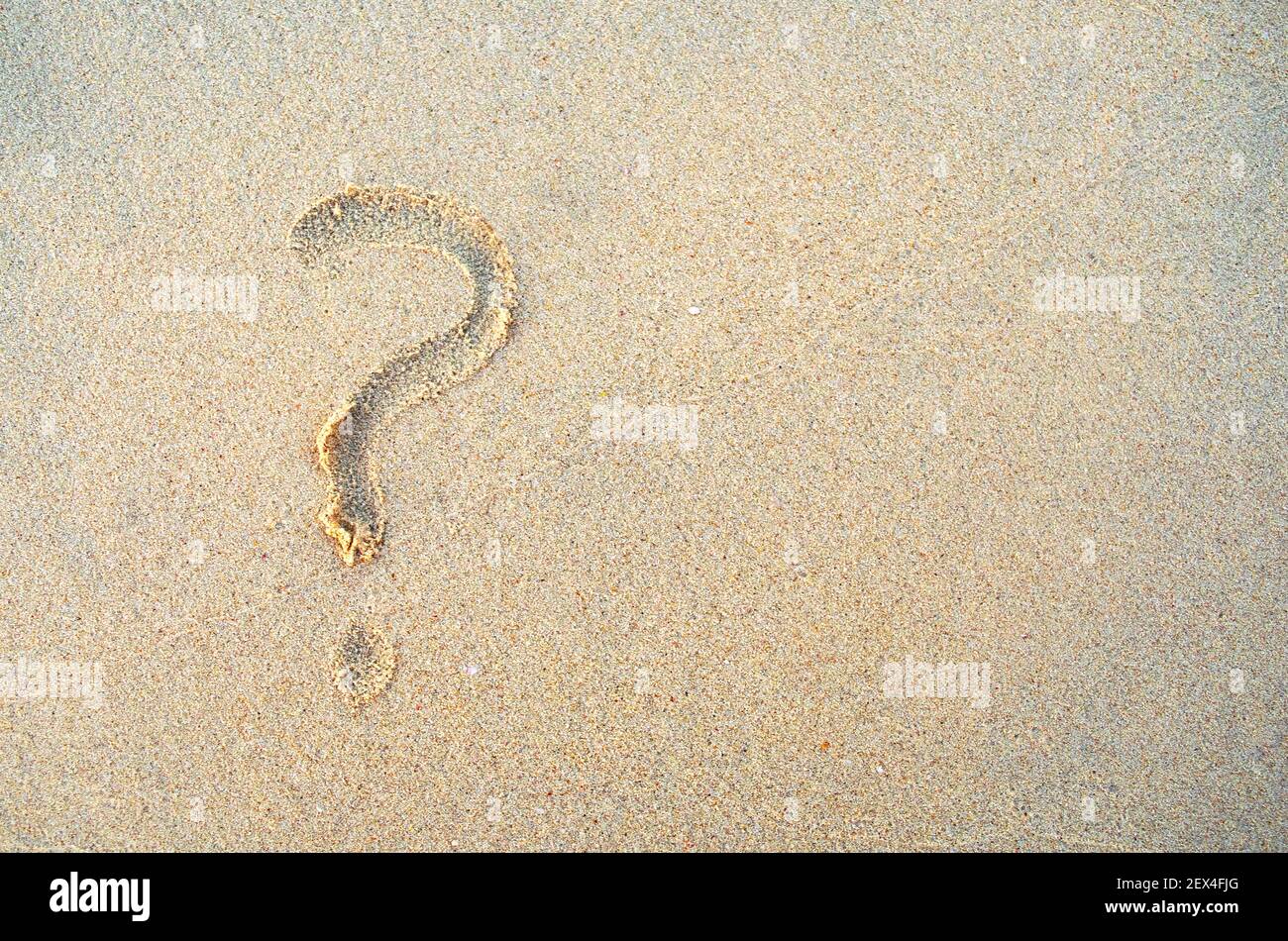 Question mark on beach sand with copy space. Question sign is written ...