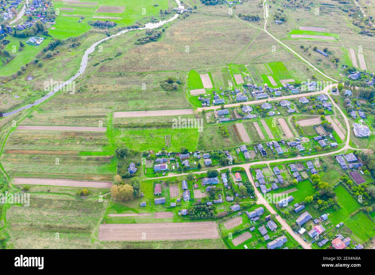 Beautiful small green village from above, dirt roads, streets ...
