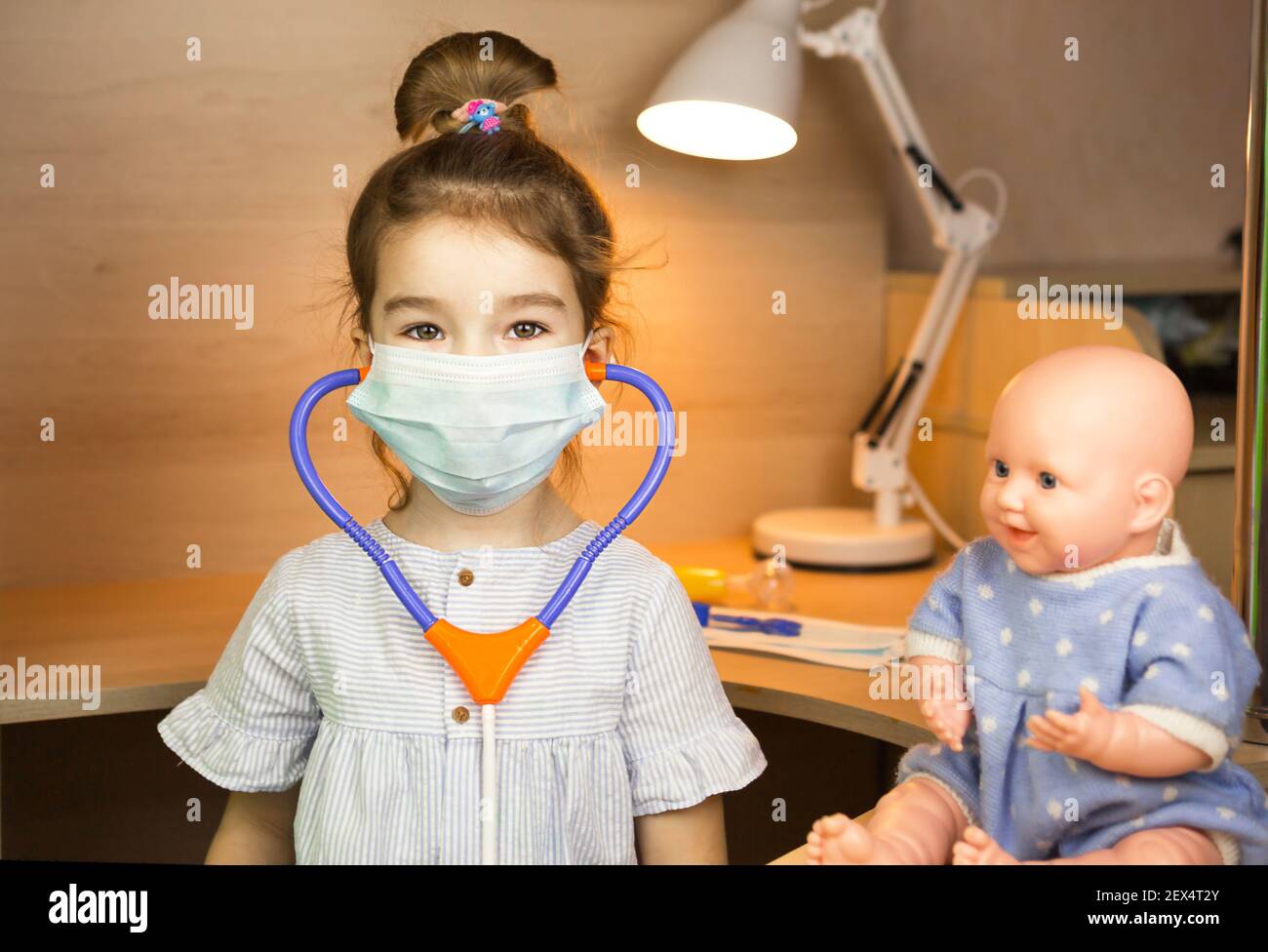 A girl with a doll plays doctor, a nurse listens to the baby through a ...