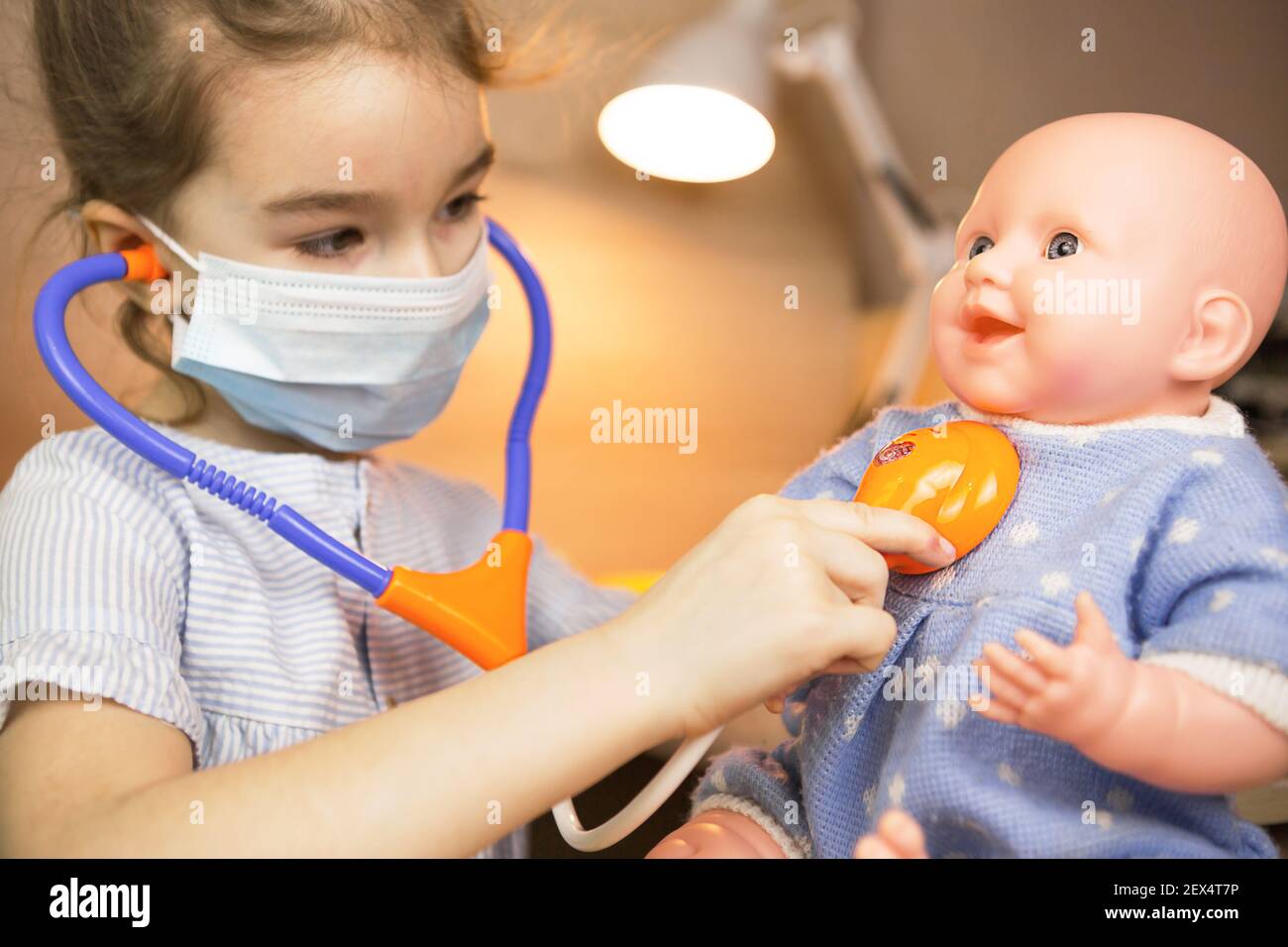 A girl with a doll plays doctor, a nurse listens to the baby through a ...