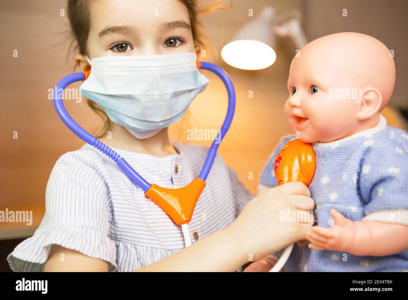 A girl with a doll plays doctor, a nurse listens to the baby through a ...