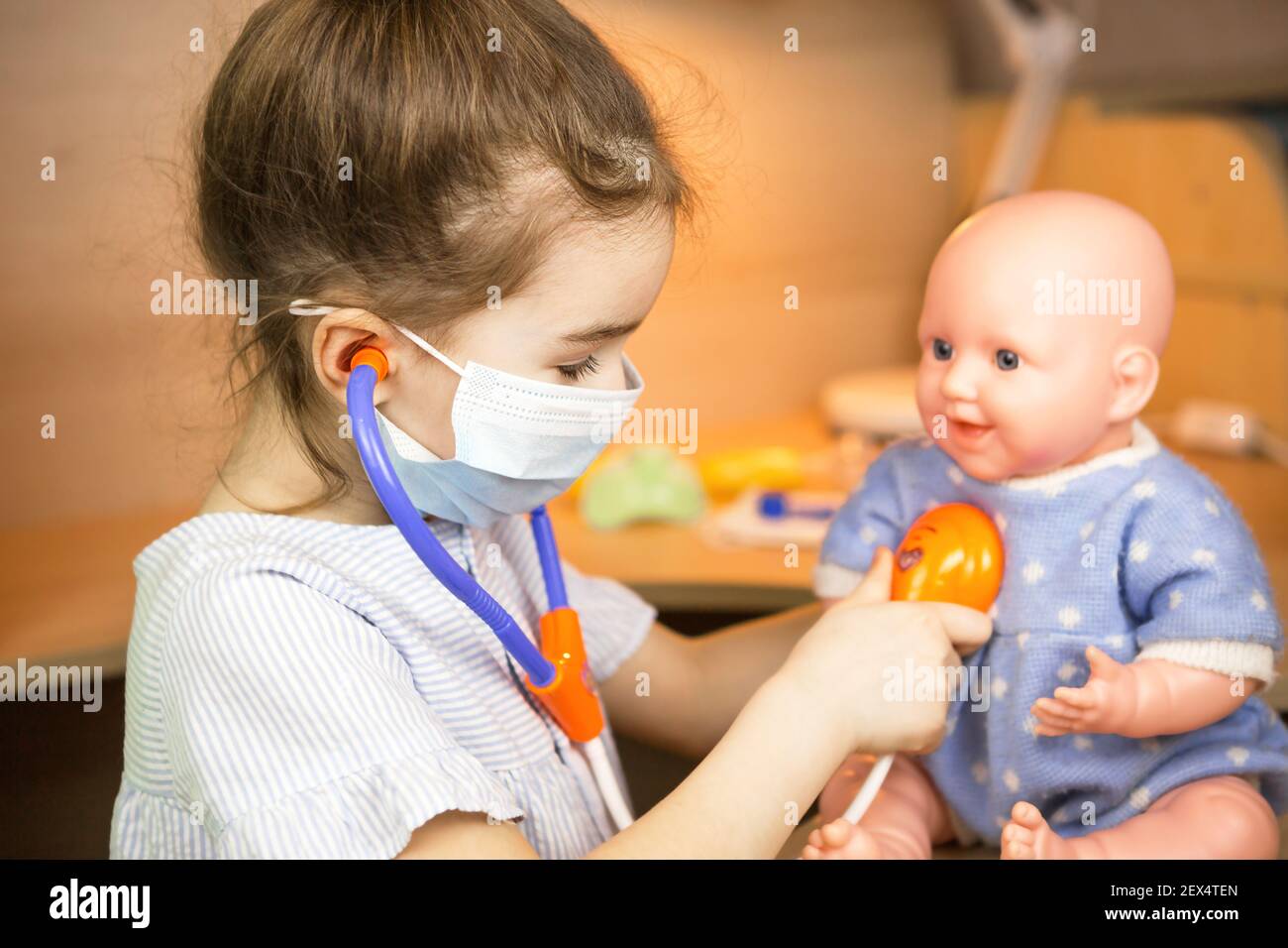 A girl with a doll plays doctor, a nurse listens to the baby through a ...