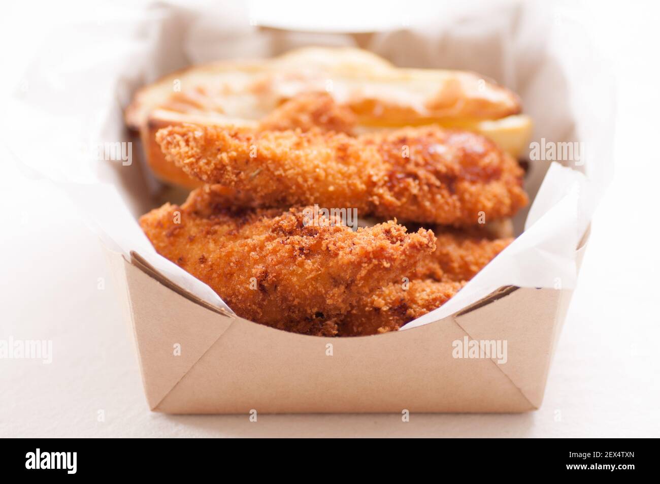 breaded chicken fingers and fries in a take out container Stock Photo ...
