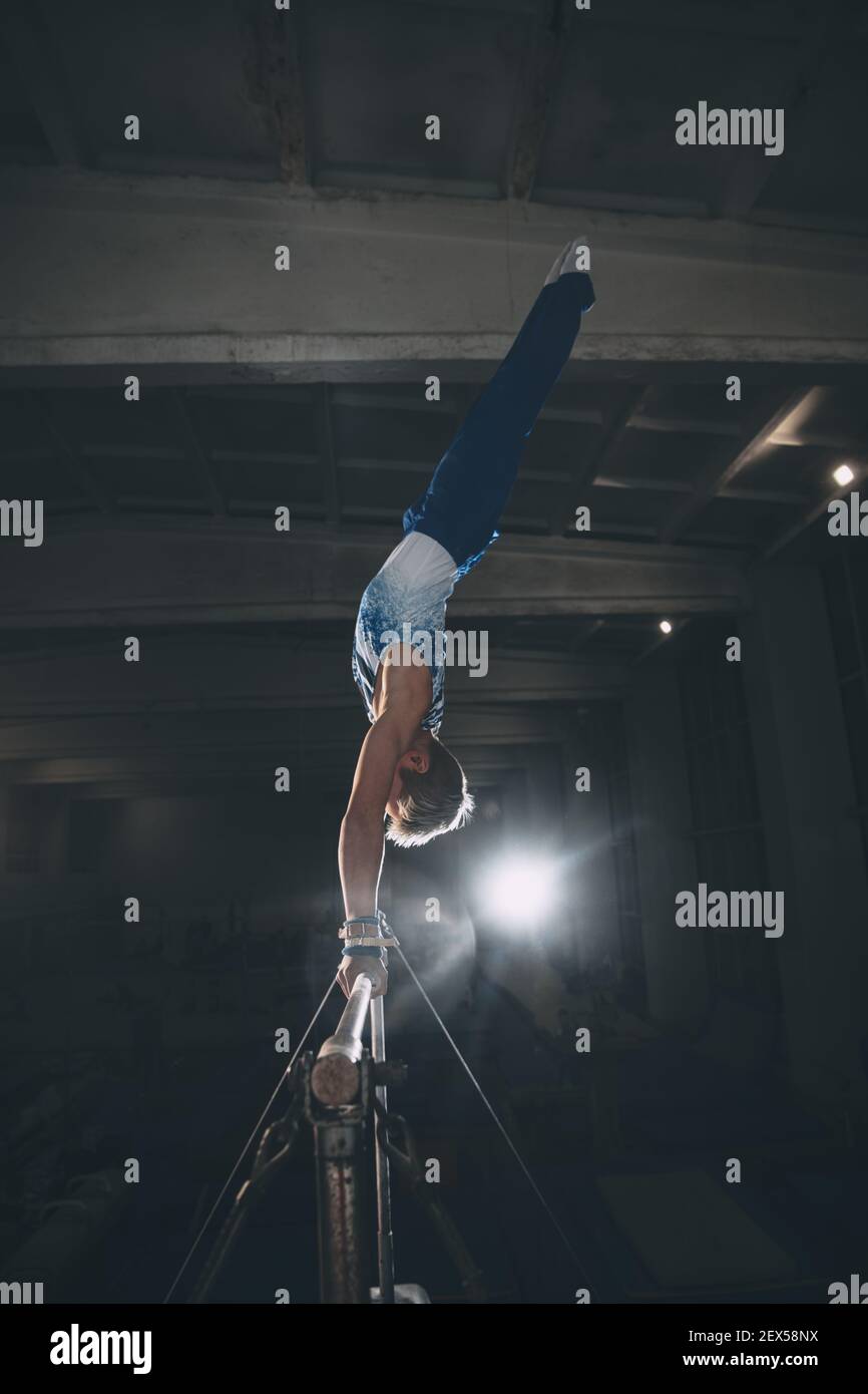 Flying. Little male gymnast training in gym, composed and active ...