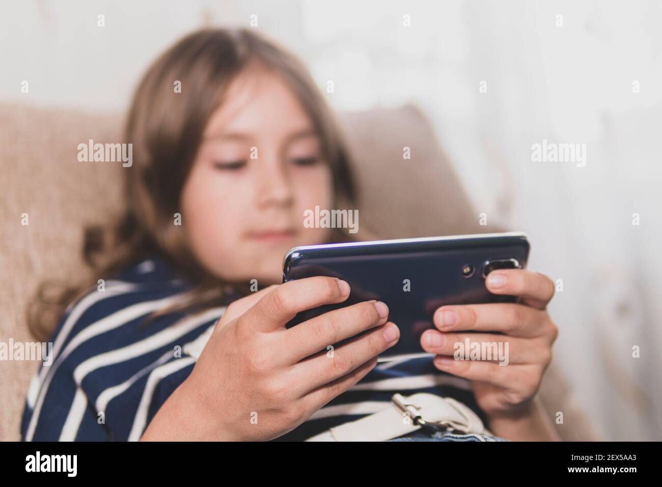 Little girl child kid using phone tablet computer playing games lying ...
