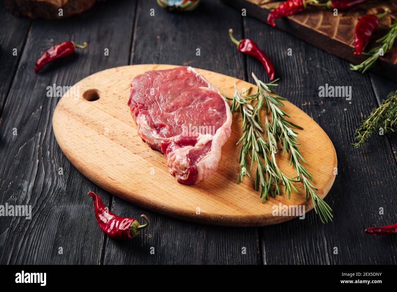 Side view on raw piece of meat with rosemary Stock Photo - Alamy