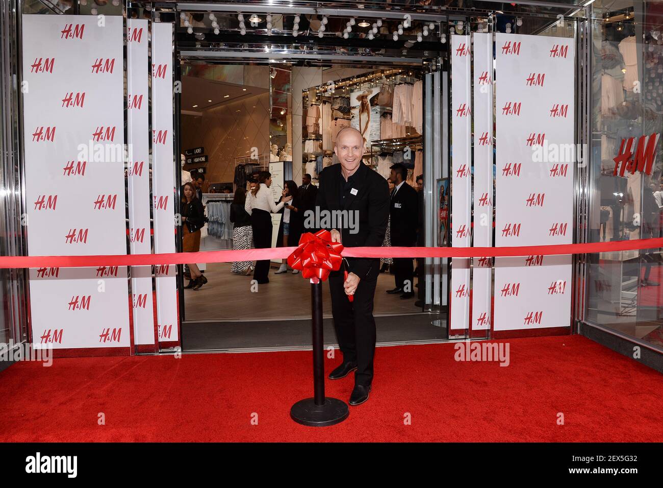 H&M president Daniel Kulle prepares to cut the ribbon for the H&M ...