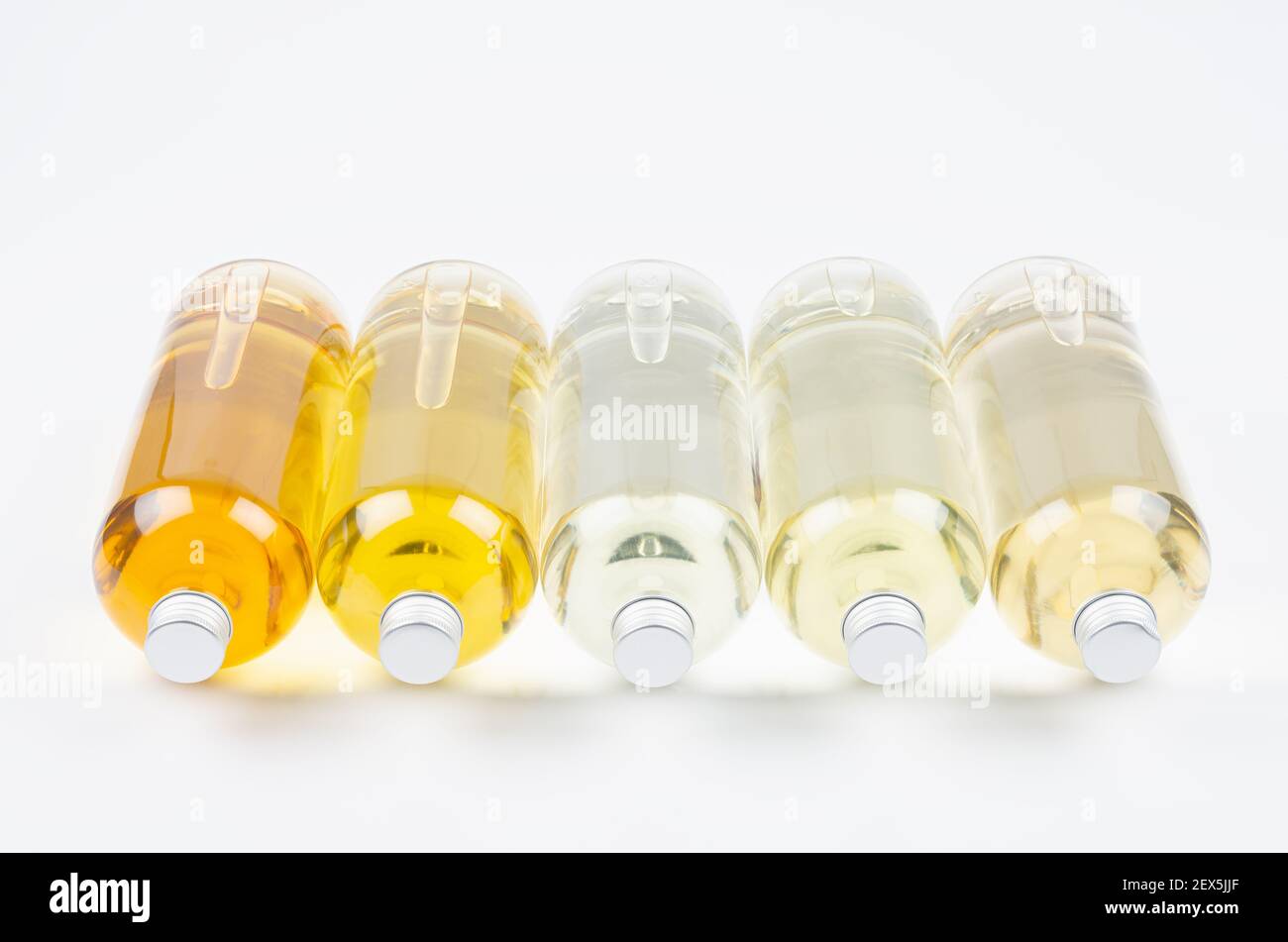 Collection lying transparent bottles with different pale colors liquid ...