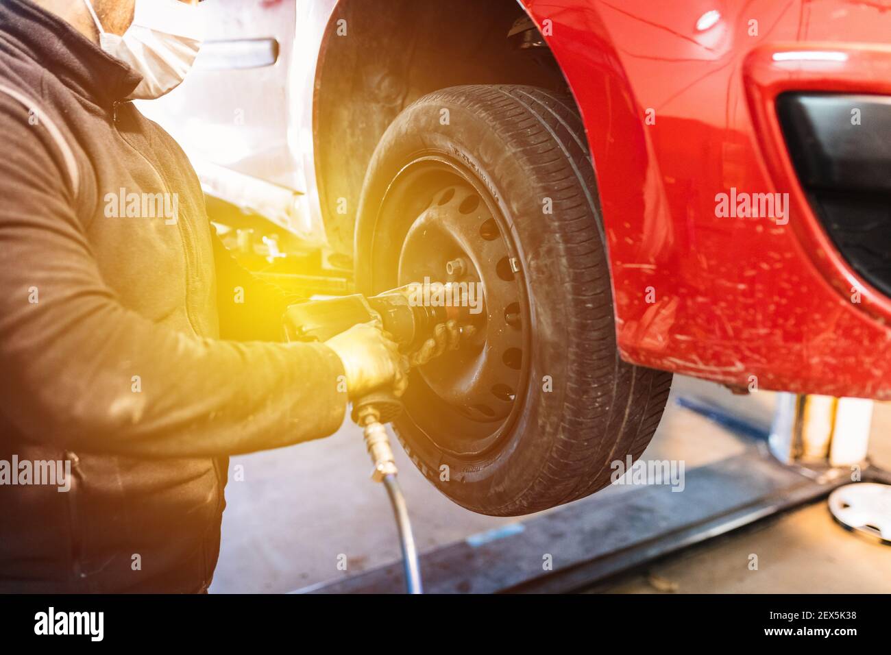 Mechanic changing car wheel in auto repair shop Stock Photo - Alamy