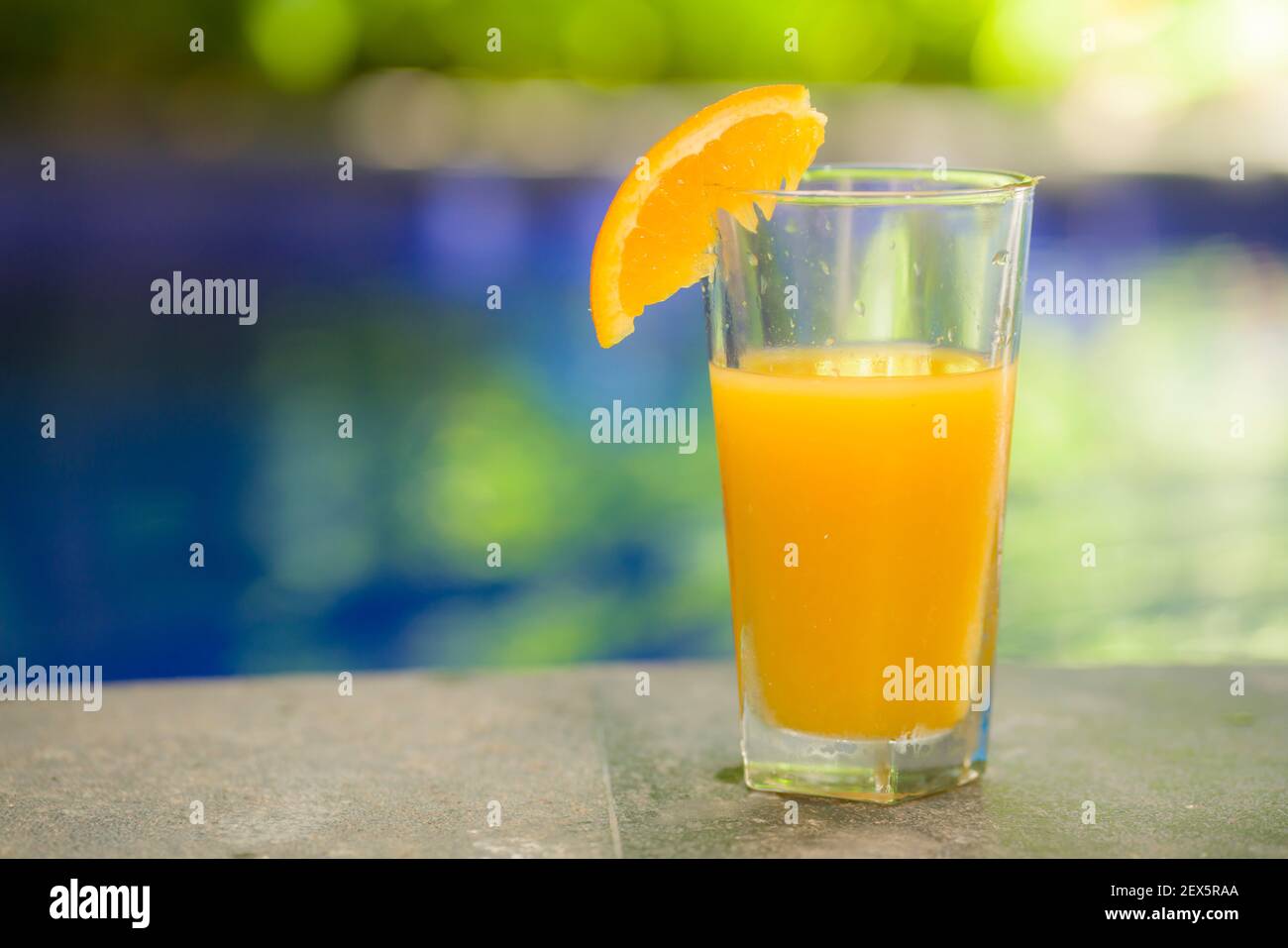 holidays and relax conceptual image of fresh orange juice by swimming ...