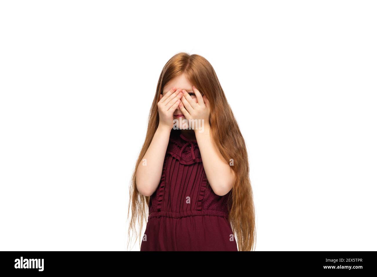 Hiding face with hands. Happy, smiley little caucasian girl on white ...