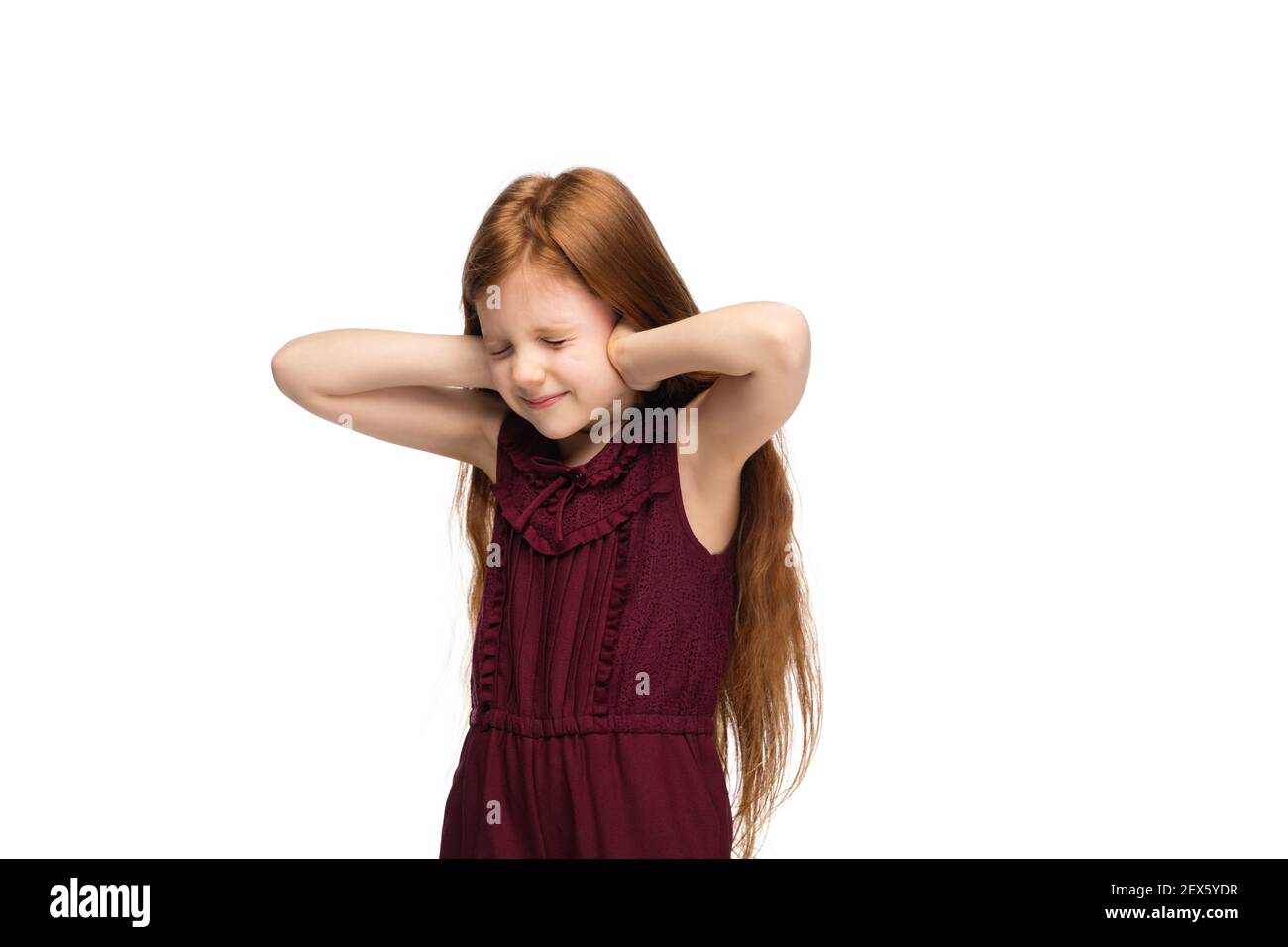 Scared, closing ears. Happy, smiley little caucasian girl isolated on ...